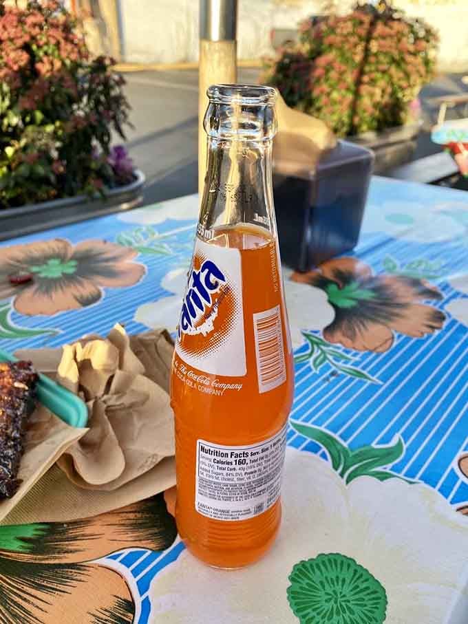 An ice-cold orange soda on a turquoise table is the perfect companion to smoky barbecue goodness.