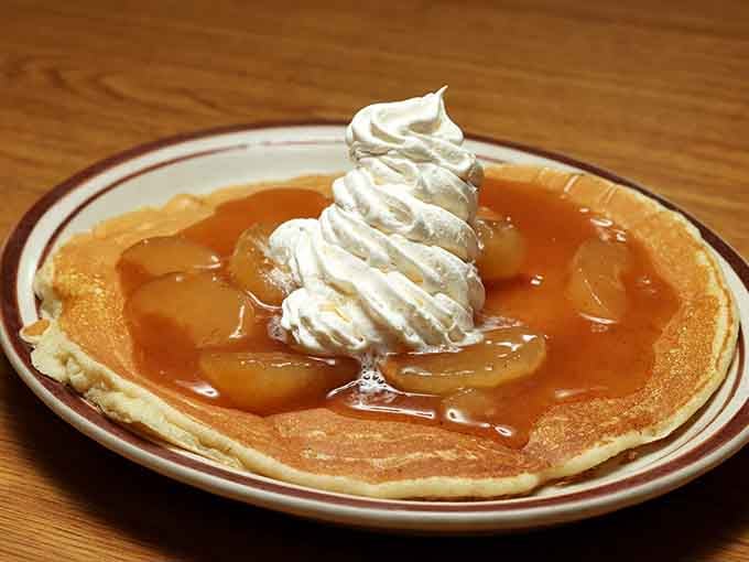 Apple pancake topped with whipped cream, proving that dessert for breakfast is not just acceptable but highly encouraged here.