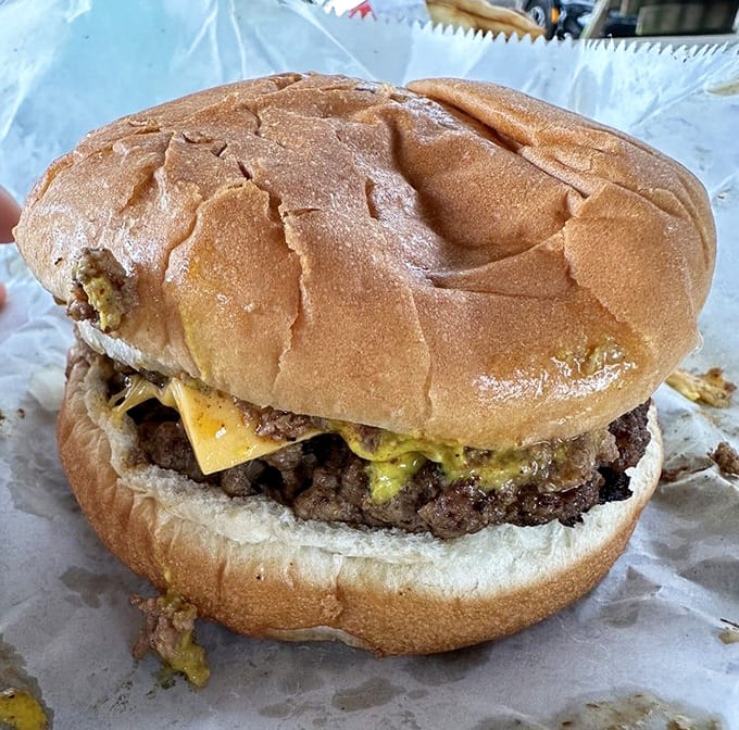 A double cheeseburger that's been loved, unwrapped, and partially devoured because some things can't wait for photos.