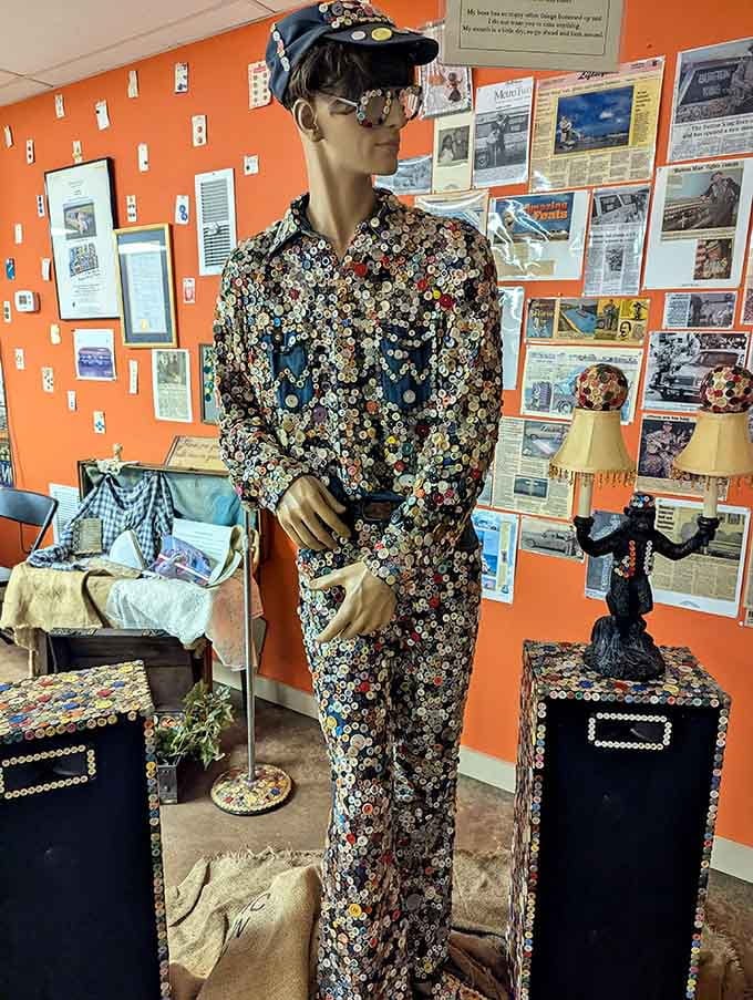 A life-sized mannequin wearing a completely button-covered suit that would make any fashion show infinitely more interesting.