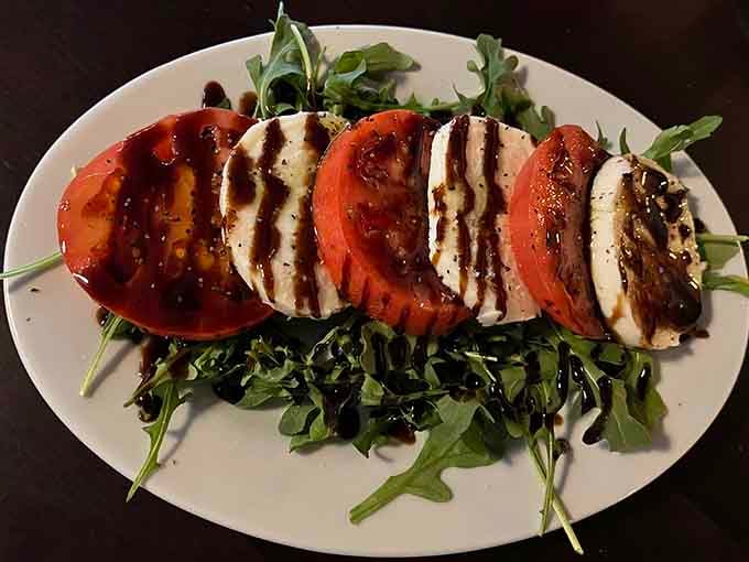 Fresh mozzarella and tomatoes arranged so beautifully, drizzled with balsamic that adds the perfect finishing touch to simplicity.