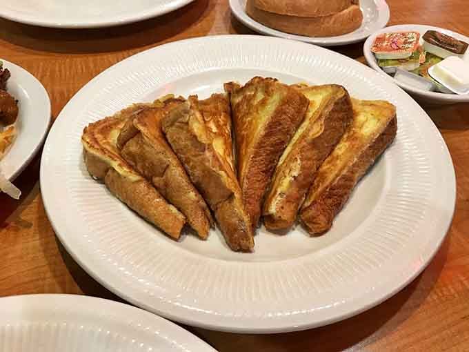 French toast that looks like it went to finishing school, topped with berries and whipped cream for maximum morning decadence.