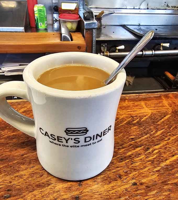 Coffee in a mug that proudly declares where the elite meet to eat, and honestly, they're not wrong about that.