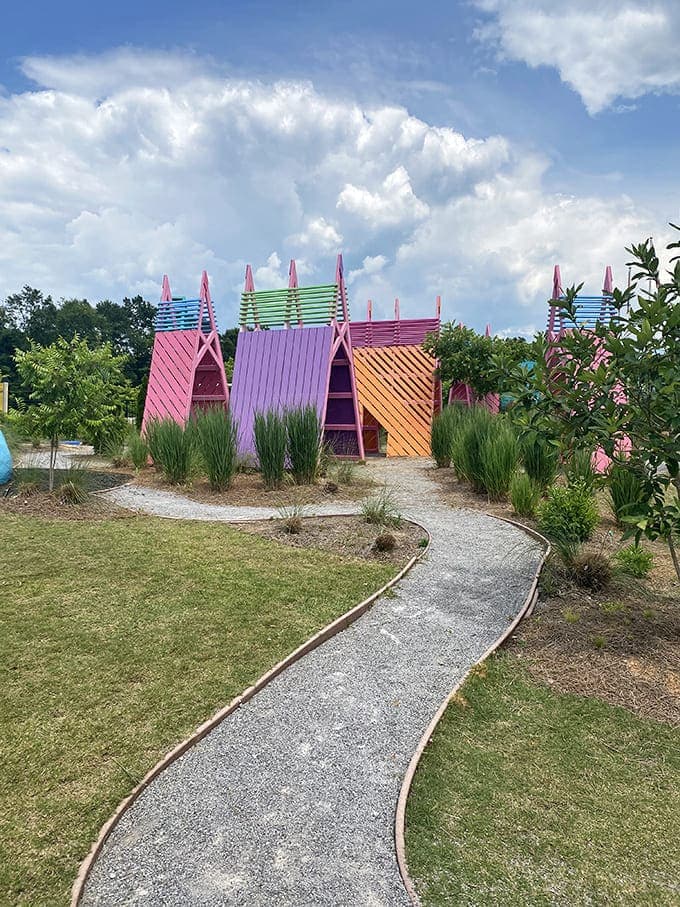Whimsical A-frame structures in rainbow hues invite imagination and play at what appears to be part of Meridian's children's attractions.