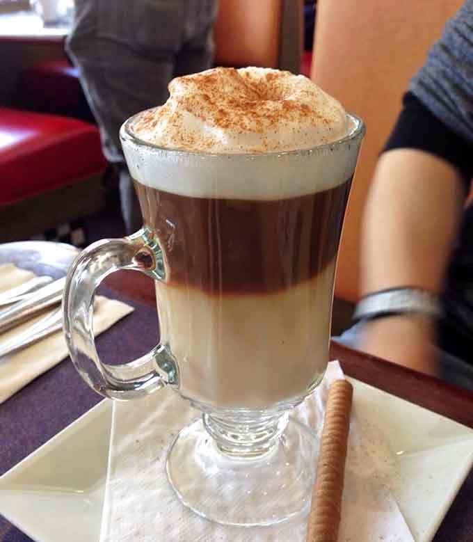 Layered cappuccino perfection topped with foam so fluffy it could double as a cloud in Wonderland.