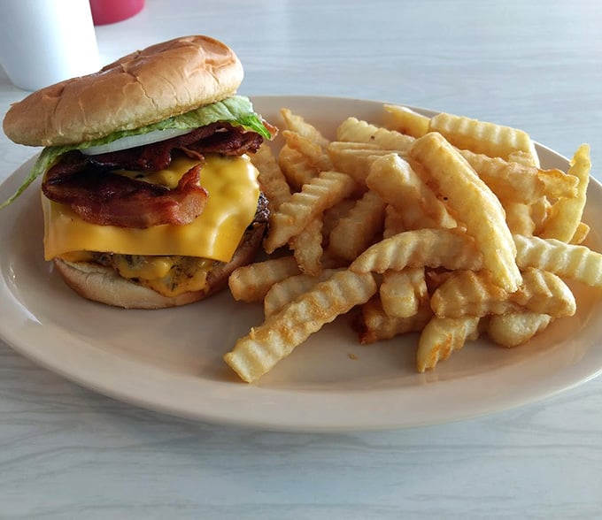 Double cheese, bacon, and waffle fries creating the kind of plate that makes diets take a vacation.