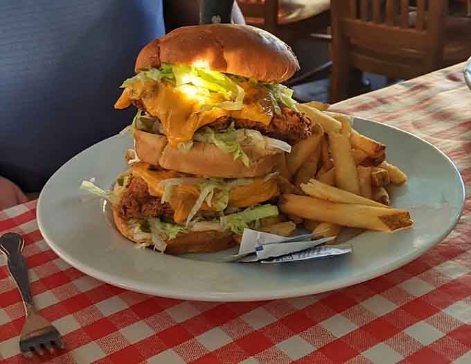 This towering burger situation requires both hands, zero shame, and possibly a structural engineering degree to navigate.