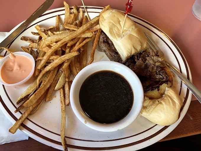 A French dip sandwich that demands respect, served with fries so perfectly golden they deserve their own Instagram account.