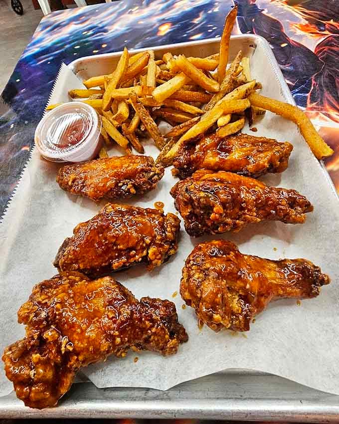 Crispy wings glazed to perfection with fries on the side, proving that anime restaurants can absolutely nail the classics.