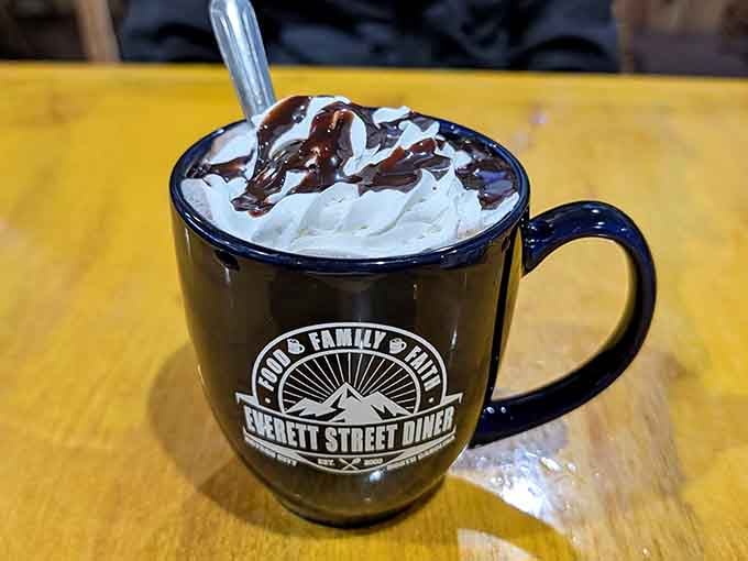 Hot chocolate topped with whipped cream and chocolate drizzle, because even grown-ups deserve to feel like kids sometimes.