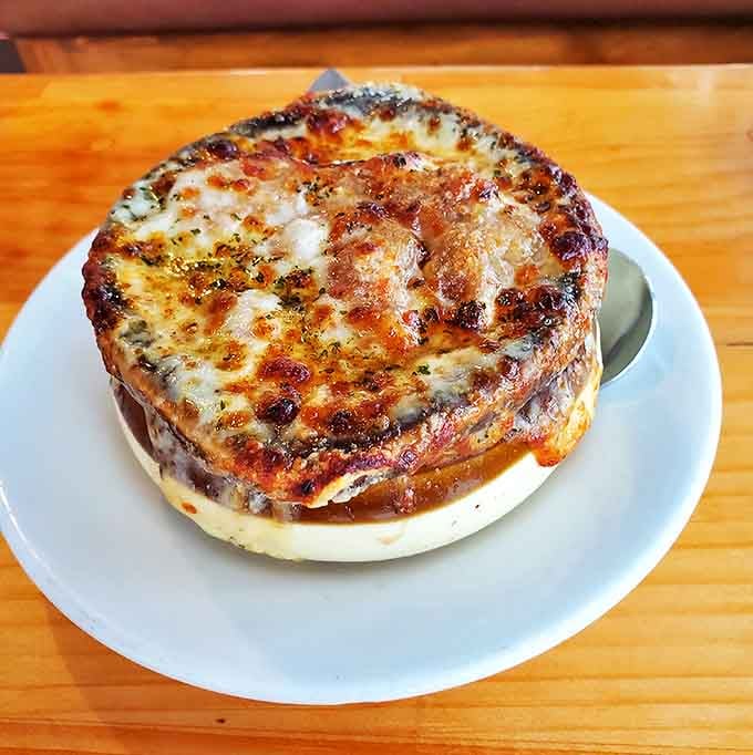 The French onion soup arrives like a warm hug on a cold day, with a blanket of melted cheese that stretches with each spoonful.