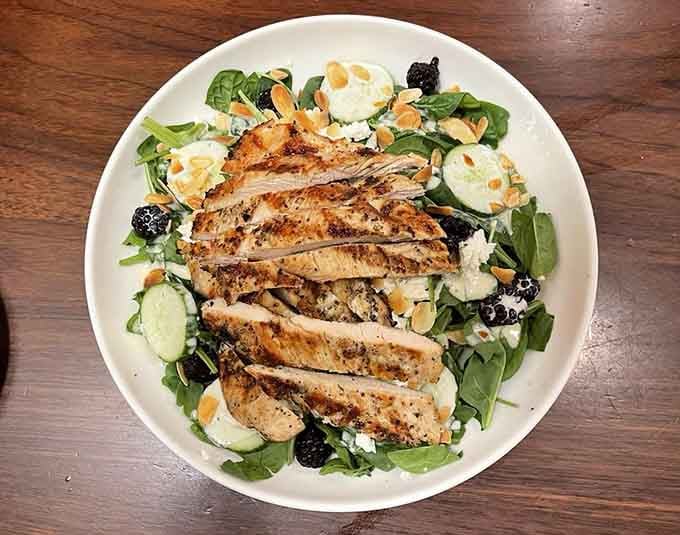 Fresh greens topped with grilled chicken create a virtuous meal before inevitable crab cake surrender.