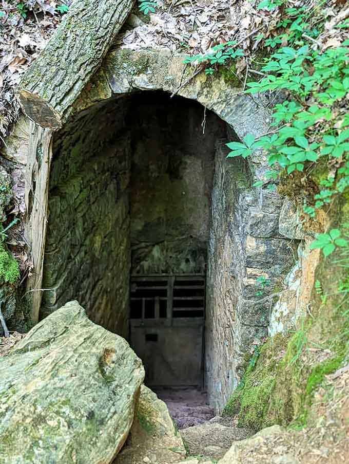 The historic entrance beckons adventurers through its stone archway, promising cool temperatures and even cooler geological wonders inside.