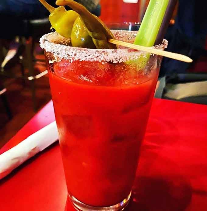 That Bloody Mary comes loaded with enough garnishes to qualify as both drink and appetizer simultaneously.