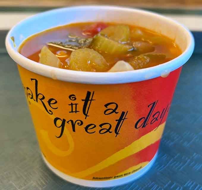 Homemade minestrone soup served in a cheerful cup, because even hot dog joints know comfort comes in many forms.