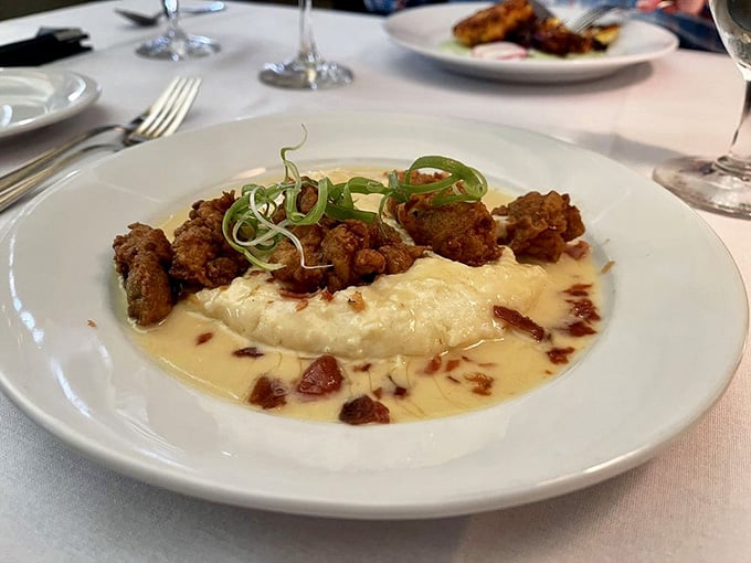 Crispy fried oysters nestled on creamy grits like they're settling in for a long, delicious Southern vacation together.