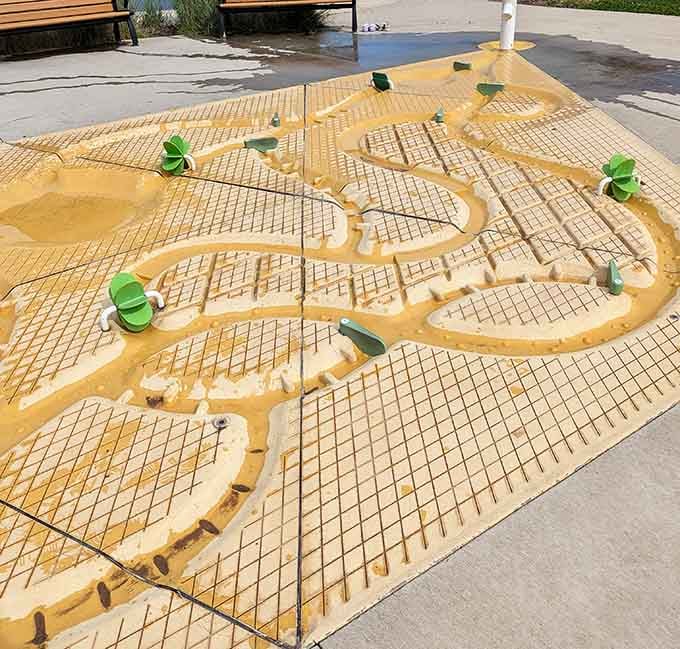 Water play area with channels and dams where kids engineer floods like tiny, enthusiastic civil engineers.