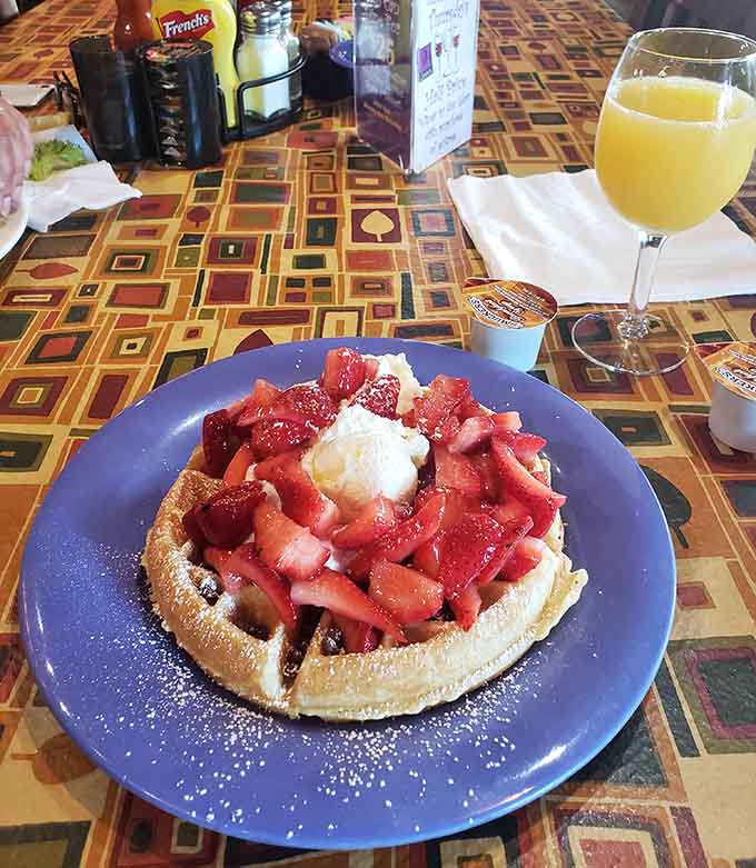 Fresh strawberries piled high on a Belgian waffle with powdered sugar is pure weekend morning bliss captured.