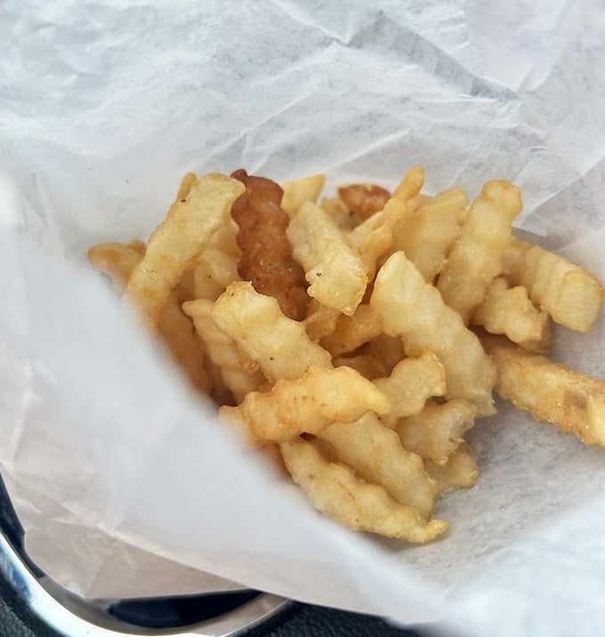Golden crinkle-cut fries piled high in paper wrapping are proof that some classics never need improving or reinventing.
