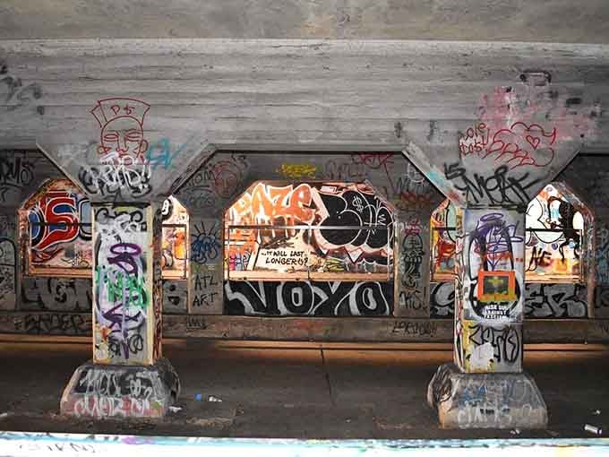 Concrete support beams transform into towering totems of urban expression, each one a vertical canvas bursting with personality.