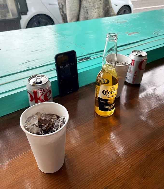 Cold drinks on a wooden table with that iconic turquoise trim framing your well-deserved meal break.