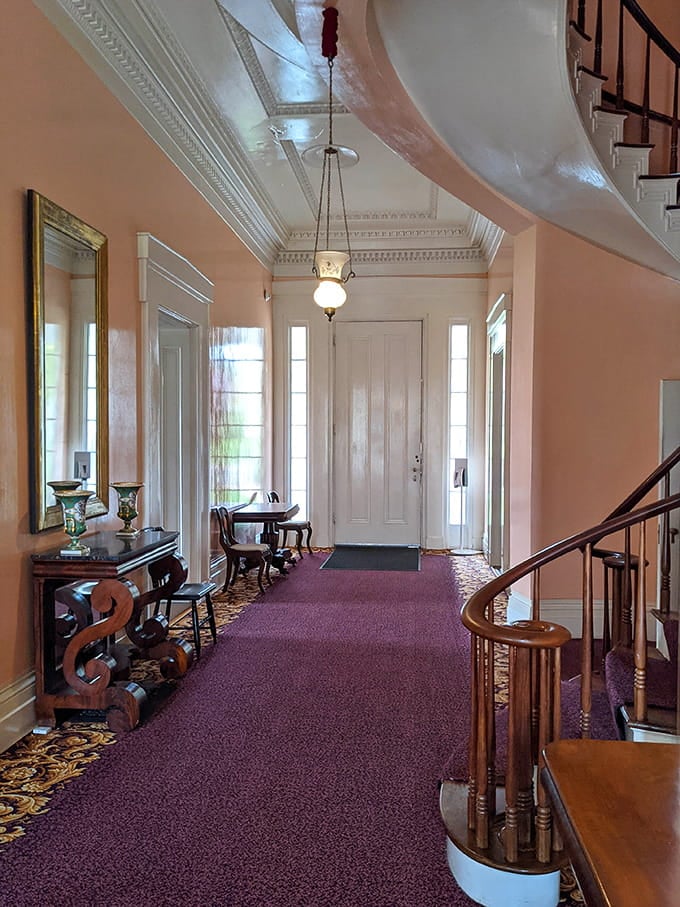 This entrance hall whispers elegance with its soaring ceilings and that mysterious spiral staircase beckoning you upward.