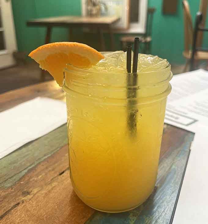 Fresh juice in a mason jar with an orange slice garnish, making hydration look like the best decision ever.