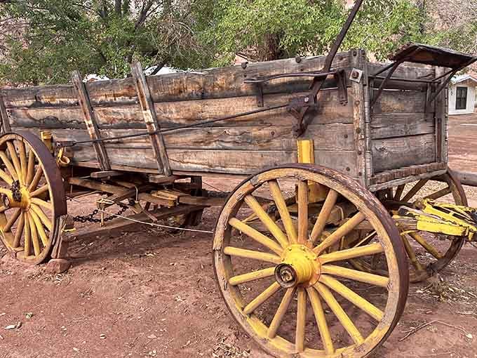 Yellow-wheeled wagon that once hauled supplies across brutal terrain, now resting after earning its well-deserved retirement.
