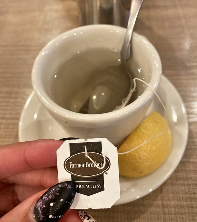 Hot tea served with a donut hole, because even the beverages come with complimentary treats at this generous establishment.