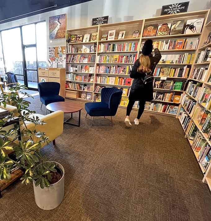 The universal bookstore stance: head tilted, completely absorbed, already planning where this one goes at home.