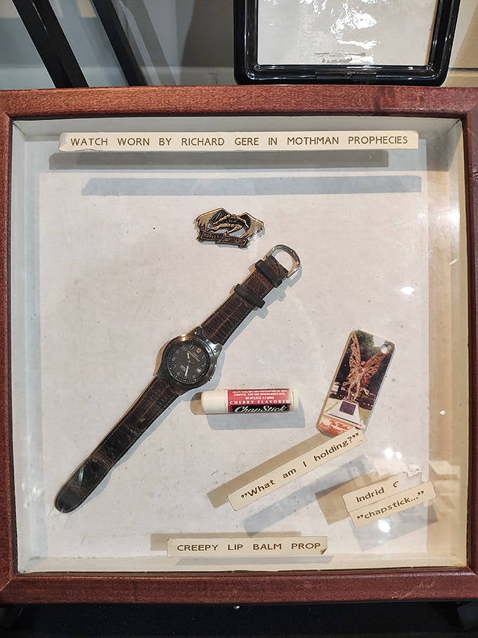 Richard Gere's watch from "The Mothman Prophecies" sits alongside other film memorabilia, proving Hollywood can't resist a good cryptid story.