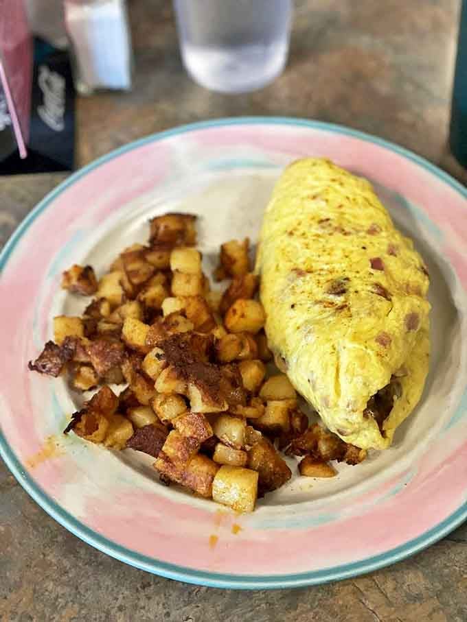 An omelet that's achieved that elusive perfect fold, paired with potatoes that deserve their own fan club.