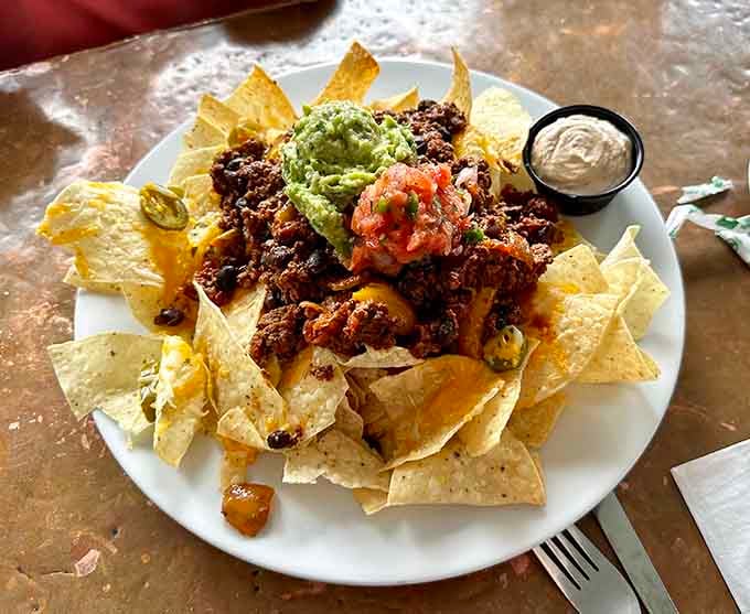 These nachos arrive piled high with all the fixings, because subtlety has no place in proper comfort food.
