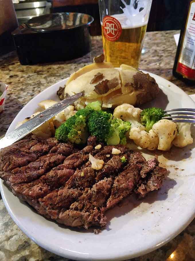 Sliced steak revealing that perfect medium-rare interior, paired with broccoli and cauliflower that actually look appetizing for once.