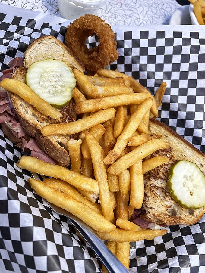 The sandwich that launched a thousand napkins&mdash;a proper Reuben served on checkered paper, where fries dare to climb aboard like eager hitchhikers.