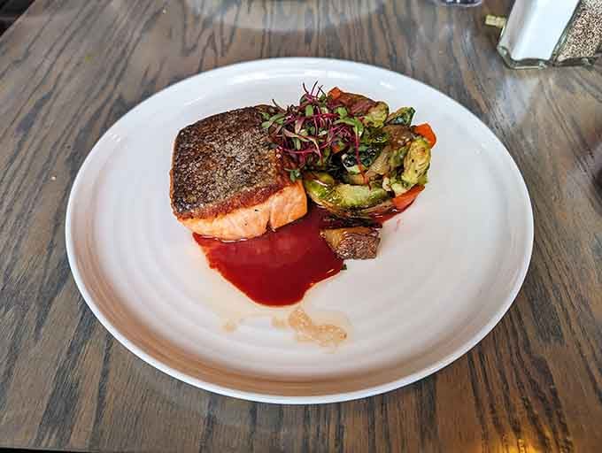 Salmon with a sear so perfect it deserves its own cooking show, nestled alongside vegetables that didn't give their lives in vain.