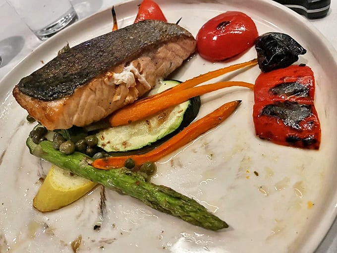 Salmon that looks like it jumped from stream to plate, surrounded by a garden of colorful vegetables. The ocean and farm having a delicious conversation.