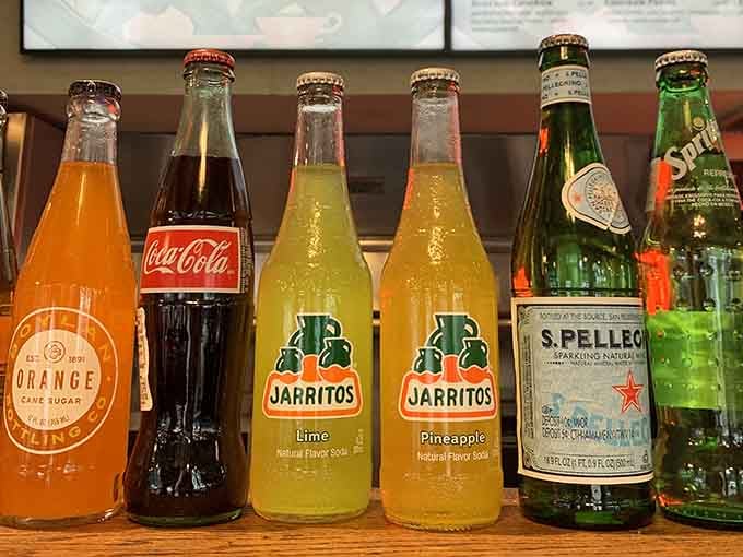 Classic glass-bottled sodas lined up like soldiers, ready to wash down your mountain of delicious meat choices.