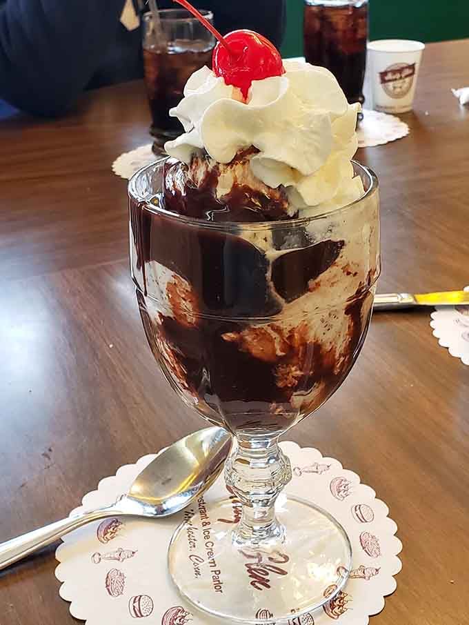 Hot fudge cascading over vanilla in a proper sundae glass, served exactly how your grandparents remember it tasting.