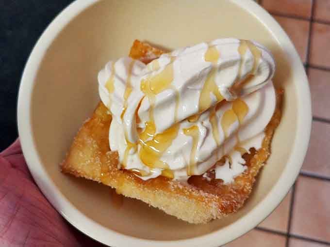 Dessert nirvana: A crispy sopapilla crowned with a cloud of whipped cream and honey drizzle that would make angels weep with joy.