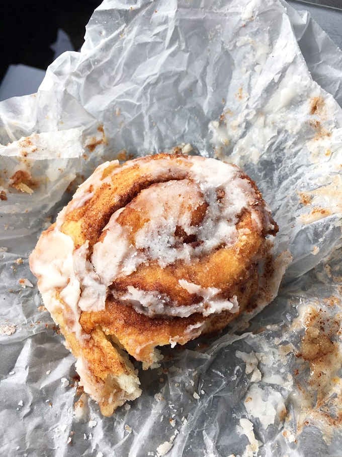 That cinnamon roll looks like it's been doing yoga, all twisted up and glazed to sweet perfection.