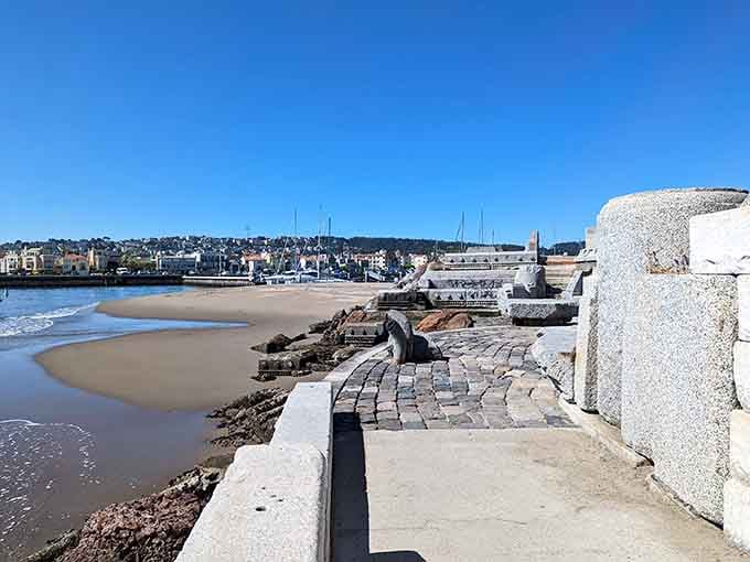 Cobblestone pathways wind through carved stone benches, creating an intimate space for contemplation and wave-watching.
