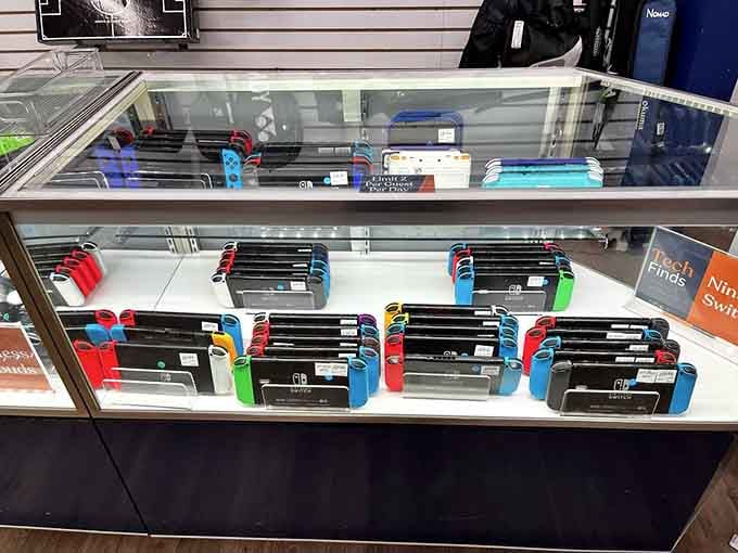 Gaming consoles in their colorful glory, proving that even Nintendo Switches can't escape the baggage claim chaos.