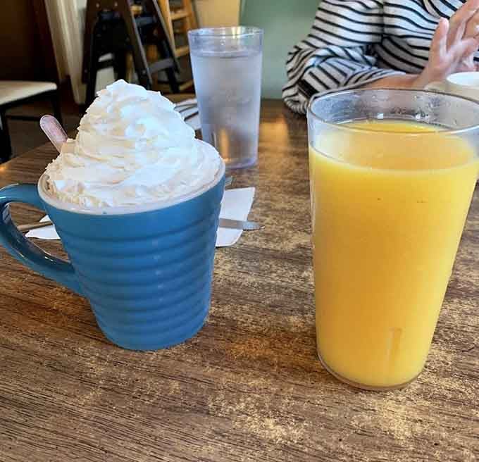 Hot chocolate topped with whipped cream peaks and fresh orange juice, because balance is important at breakfast.