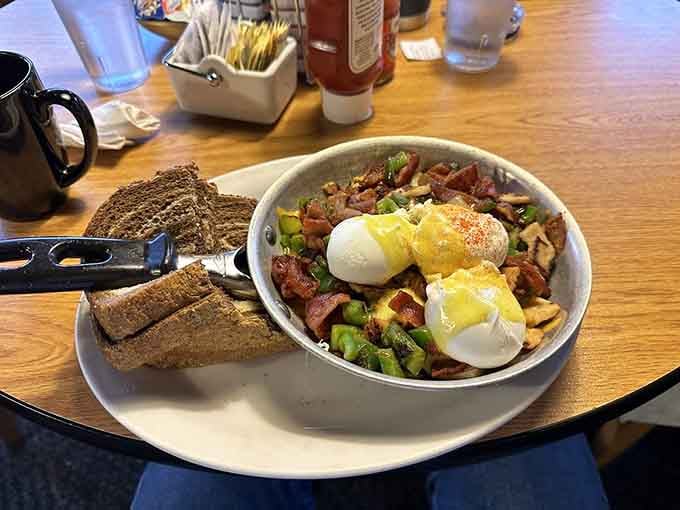 That skillet overflowing with potatoes, vegetables, and perfectly poached eggs is basically a breakfast masterpiece on a single plate.