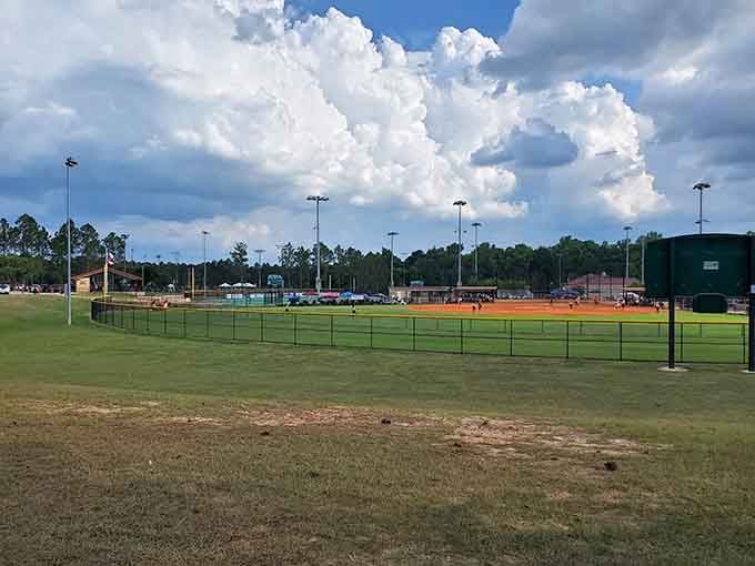 Under dramatic Southern skies, local baseball traditions continue on well-maintained fields where future stars and weekend warriors alike chase their diamond dreams.