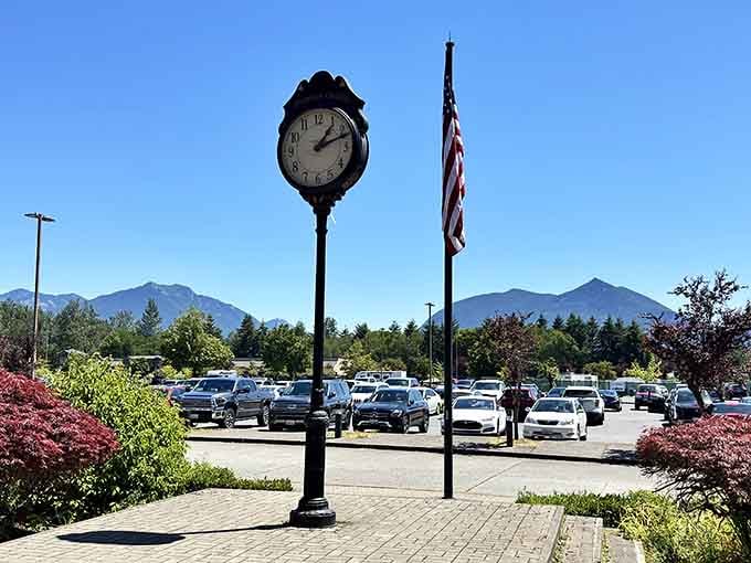 The vintage clock and Old Glory stand guard while shoppers hunt bargains, adding Main Street charm to outlet efficiency.