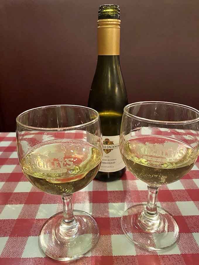 Sometimes the perfect accompaniment to a legendary pizza is simply two glasses of chilled white wine and conversation across a checkered tablecloth.