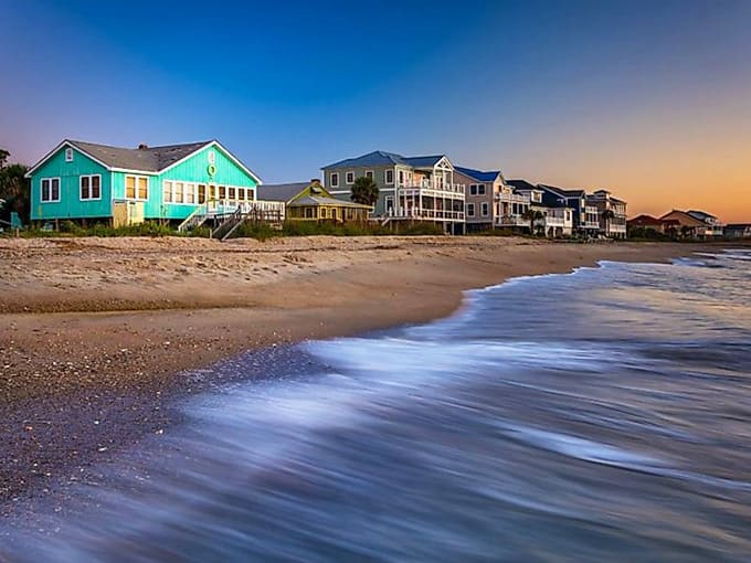 Golden hour light bathes colorful beach houses in a glow that makes you want to kick off your shoes forever.