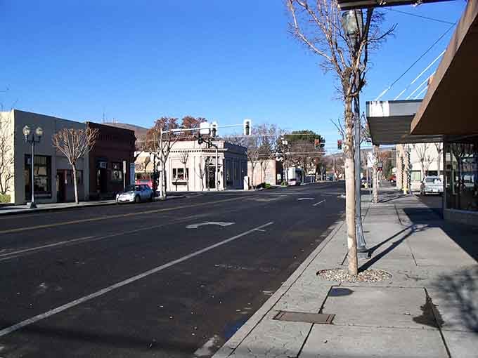 Wide-open streets stretch toward distant horizons where big sky country meets agricultural heartland in peaceful coexistence.